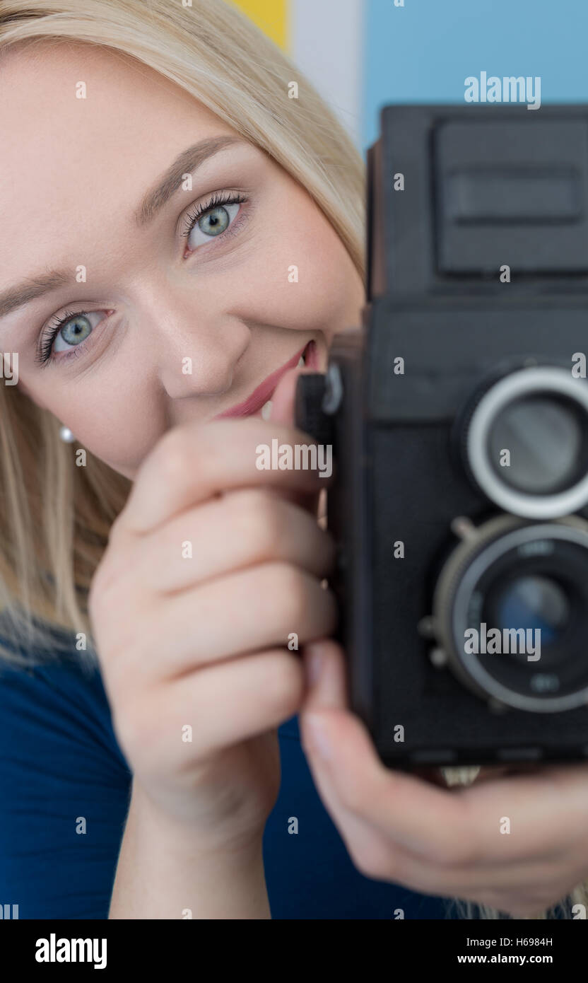 Pretty young girl with retro vintage camera standing and smiling ...