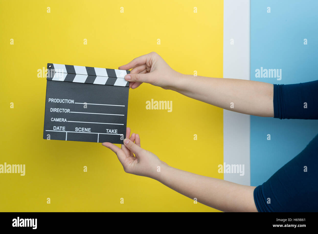 woman holding movie clapper on yellow background, cinema concept Stock ...