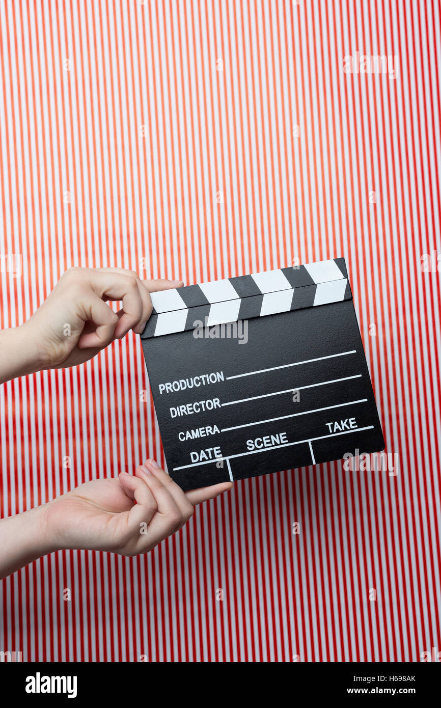 movie marker or clapper board set against a colorfull background ...