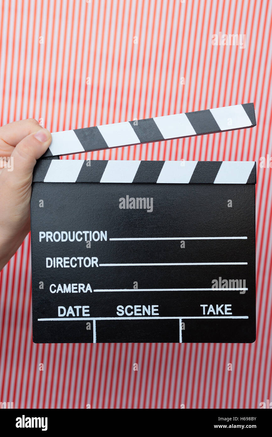 movie marker or clapper board set against a colorfull background ...