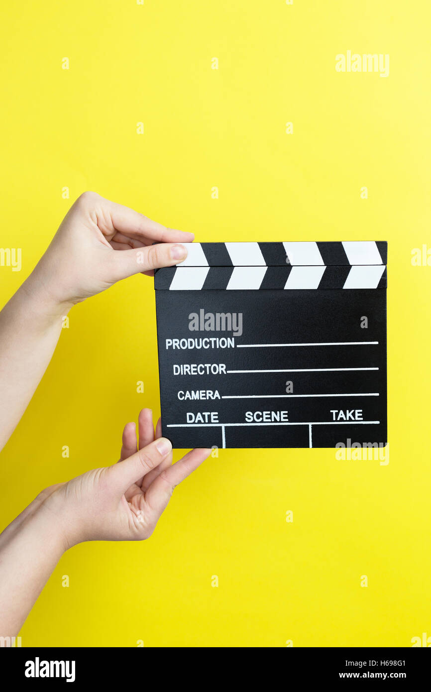 woman holding movie clapper on yellow background, cinema concept Stock ...