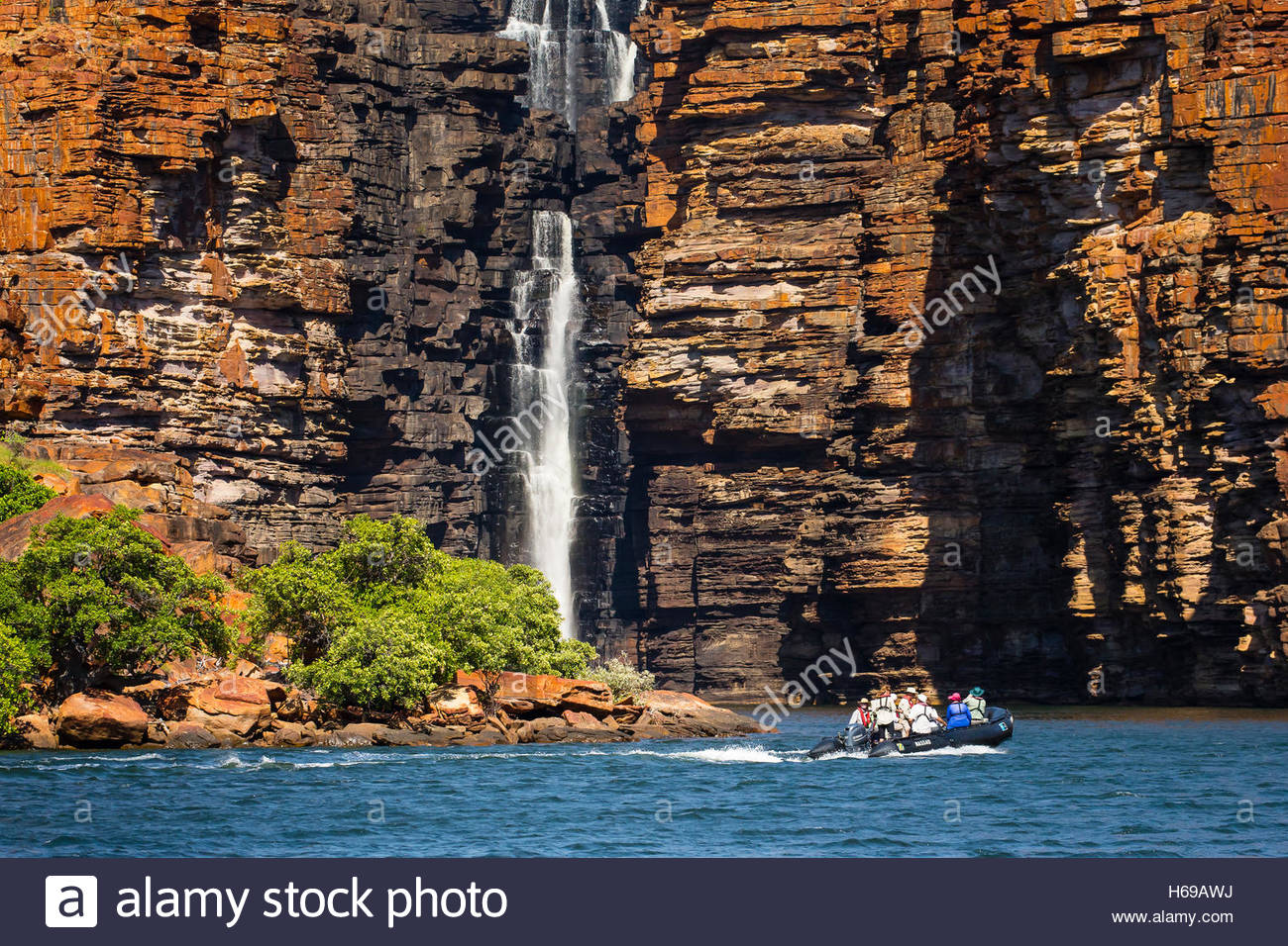 A boat near the base of a waterfall in King George Falls near Koolama ...