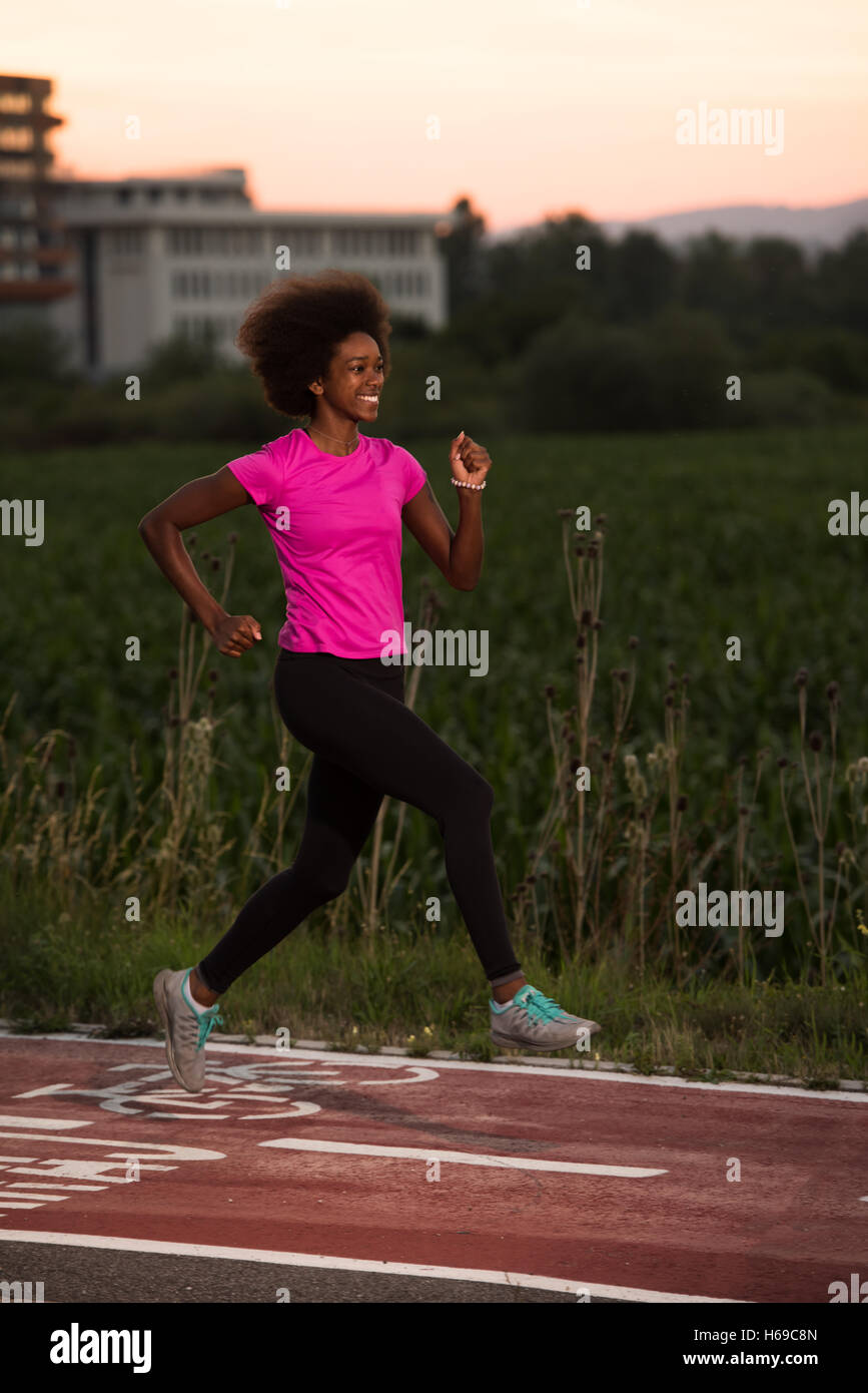 young beautiful African American woman enjoys running outside beautiful ...