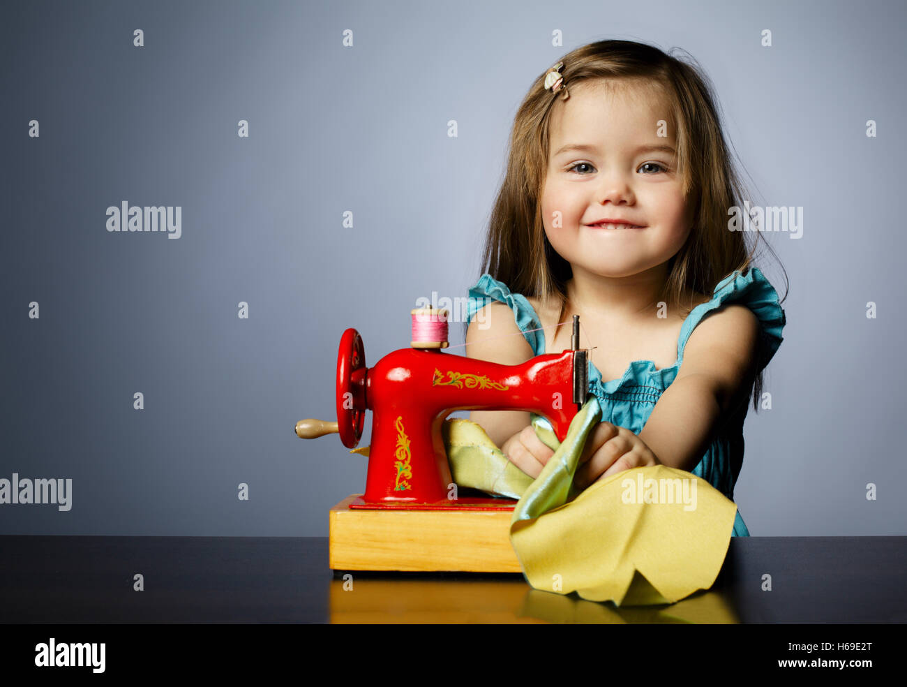 little girl is playing with sewing machine Stock Photo - Alamy