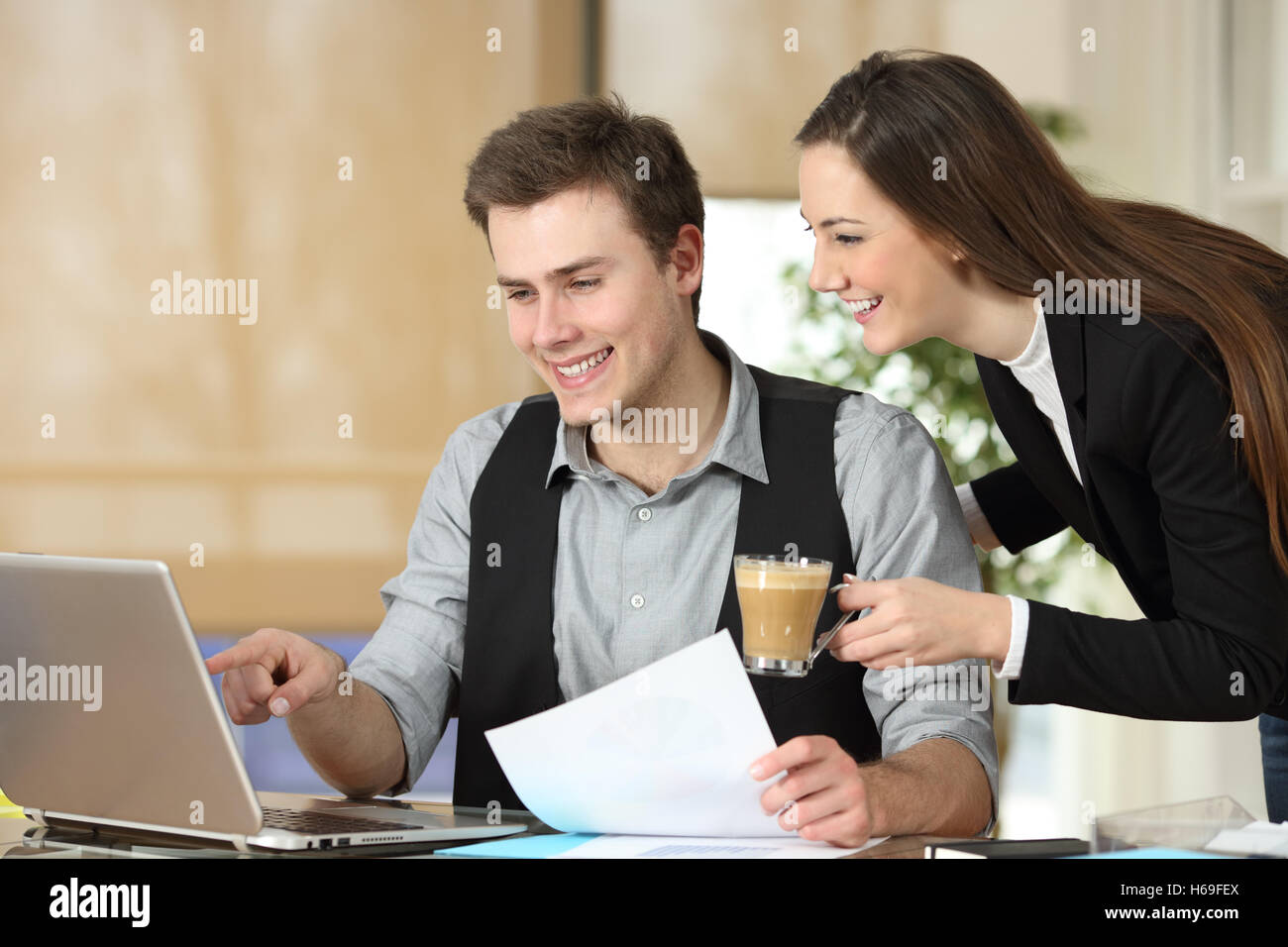 Two partners coworking watching content online in a computer on a ...