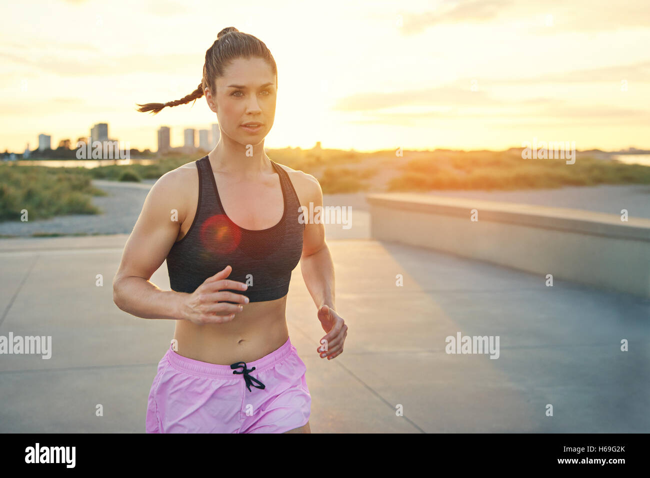 Beautiful and toned female jogger with swinging ponytail and pink ...