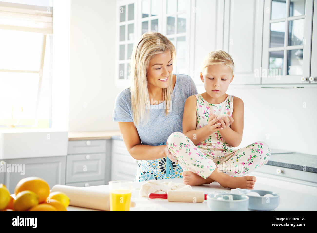 Mother working with child to prepare bread dough ingredients for baking ...