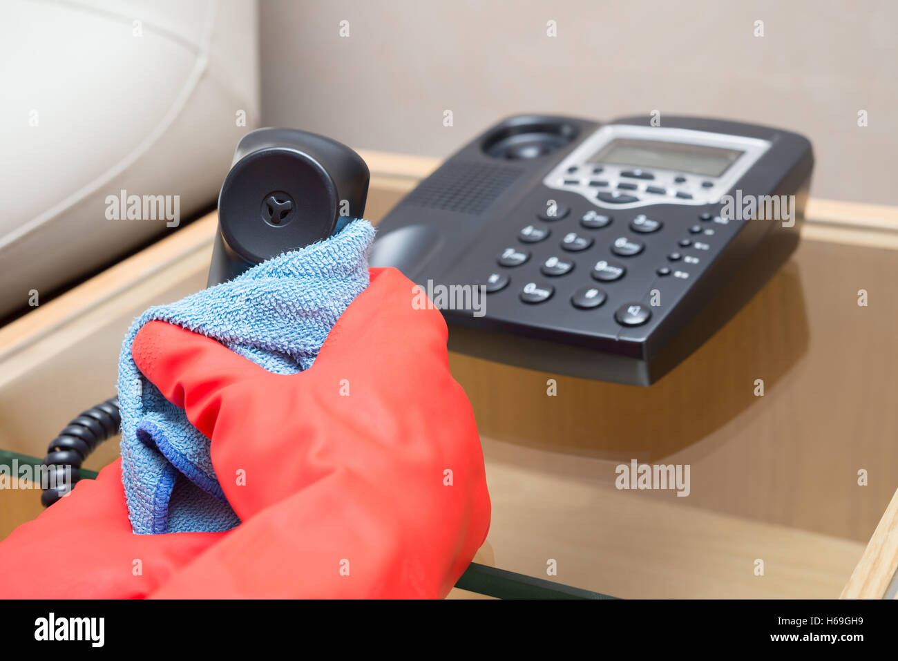 man cleaning telephone with a blue cloth Stock Photo - Alamy
