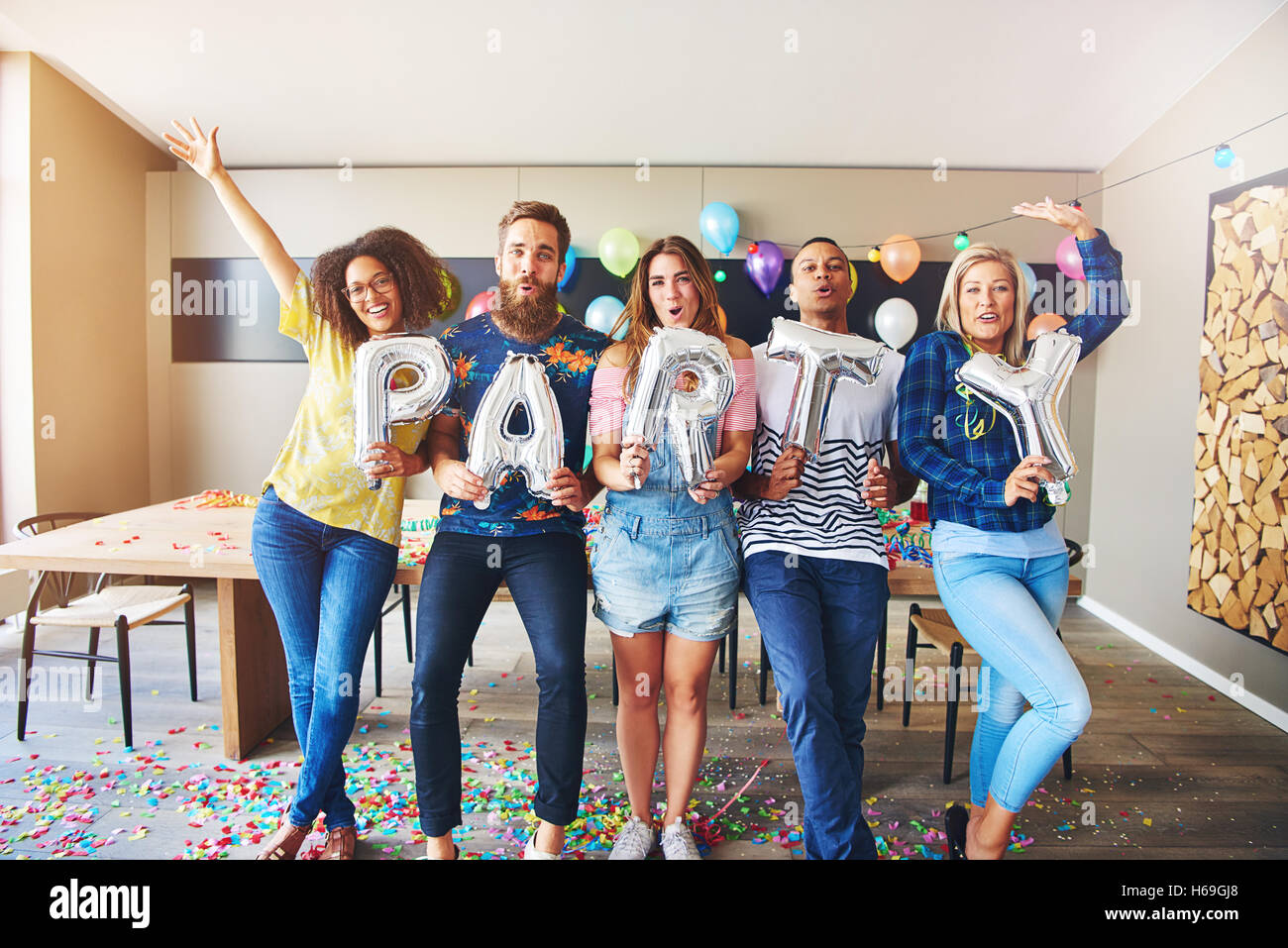 Happy group of young male and female adults holding PARTY letters as ...