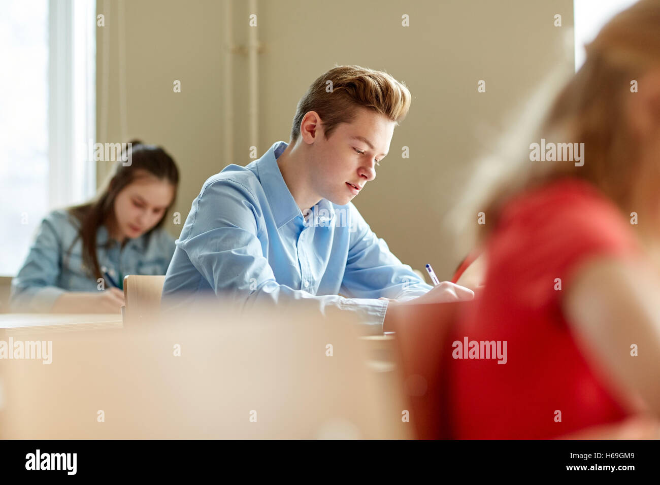 group of students with books writing school test Stock Photo - Alamy