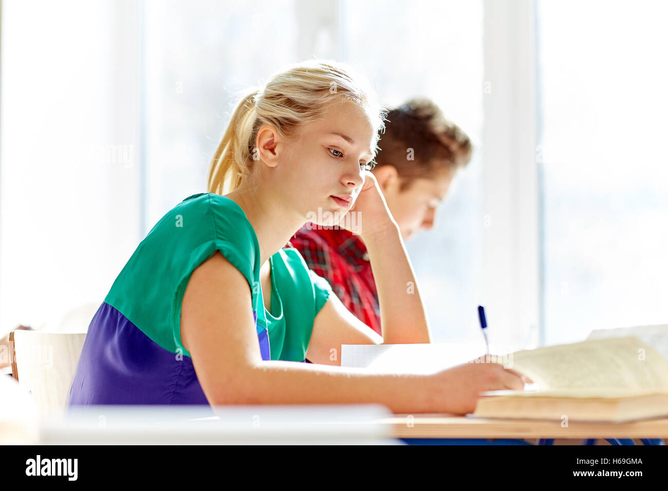 group of students with books writing school test Stock Photo - Alamy