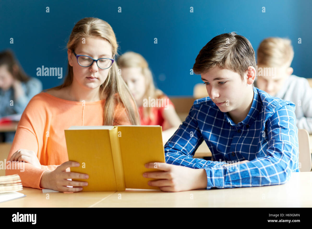 students reading book at school lesson Stock Photo - Alamy