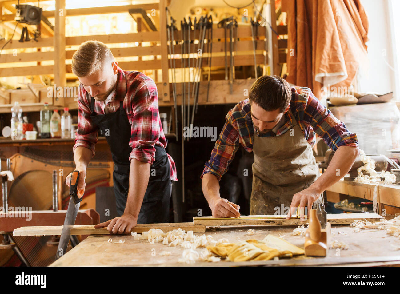 carpenters working with saw and wood at workshop Stock Photo - Alamy