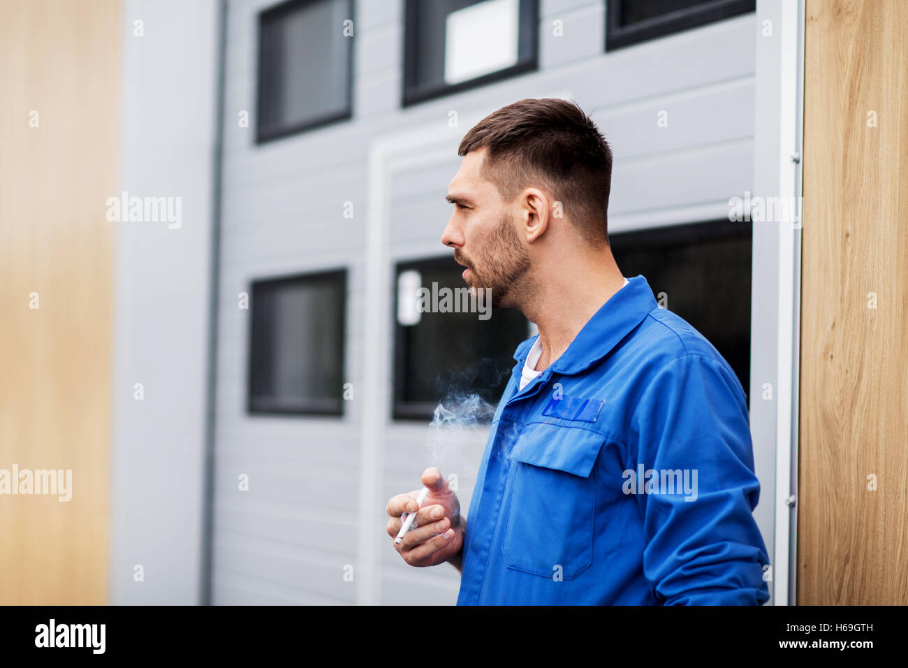auto mechanic smoking cigarette at car workshop Stock Photo - Alamy