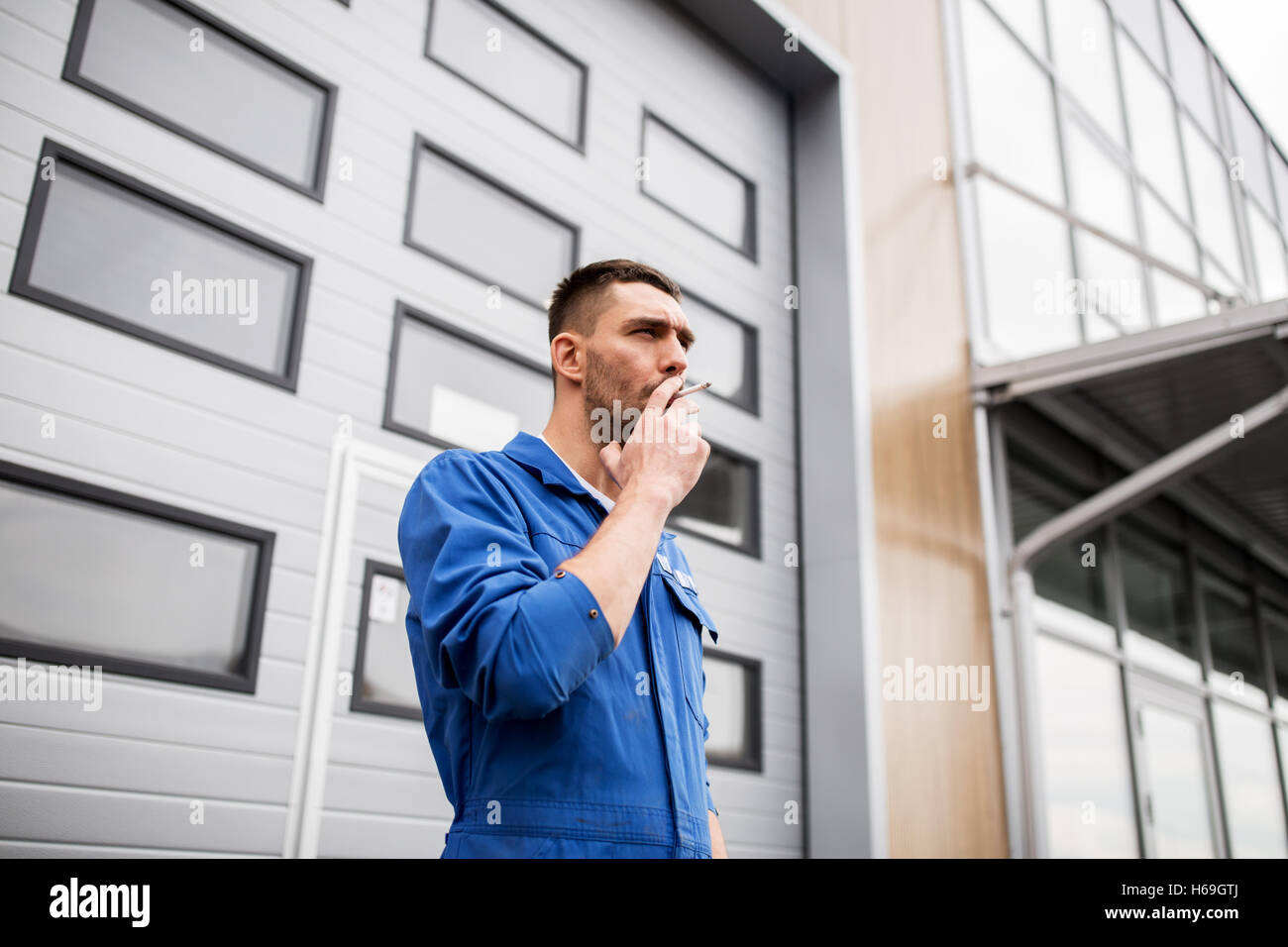 auto mechanic smoking cigarette at car workshop Stock Photo - Alamy
