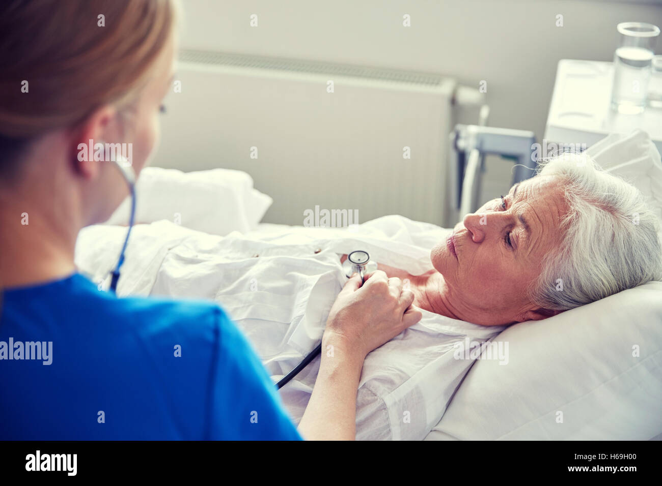 nurse with stethoscope and senior woman at clinic Stock Photo - Alamy