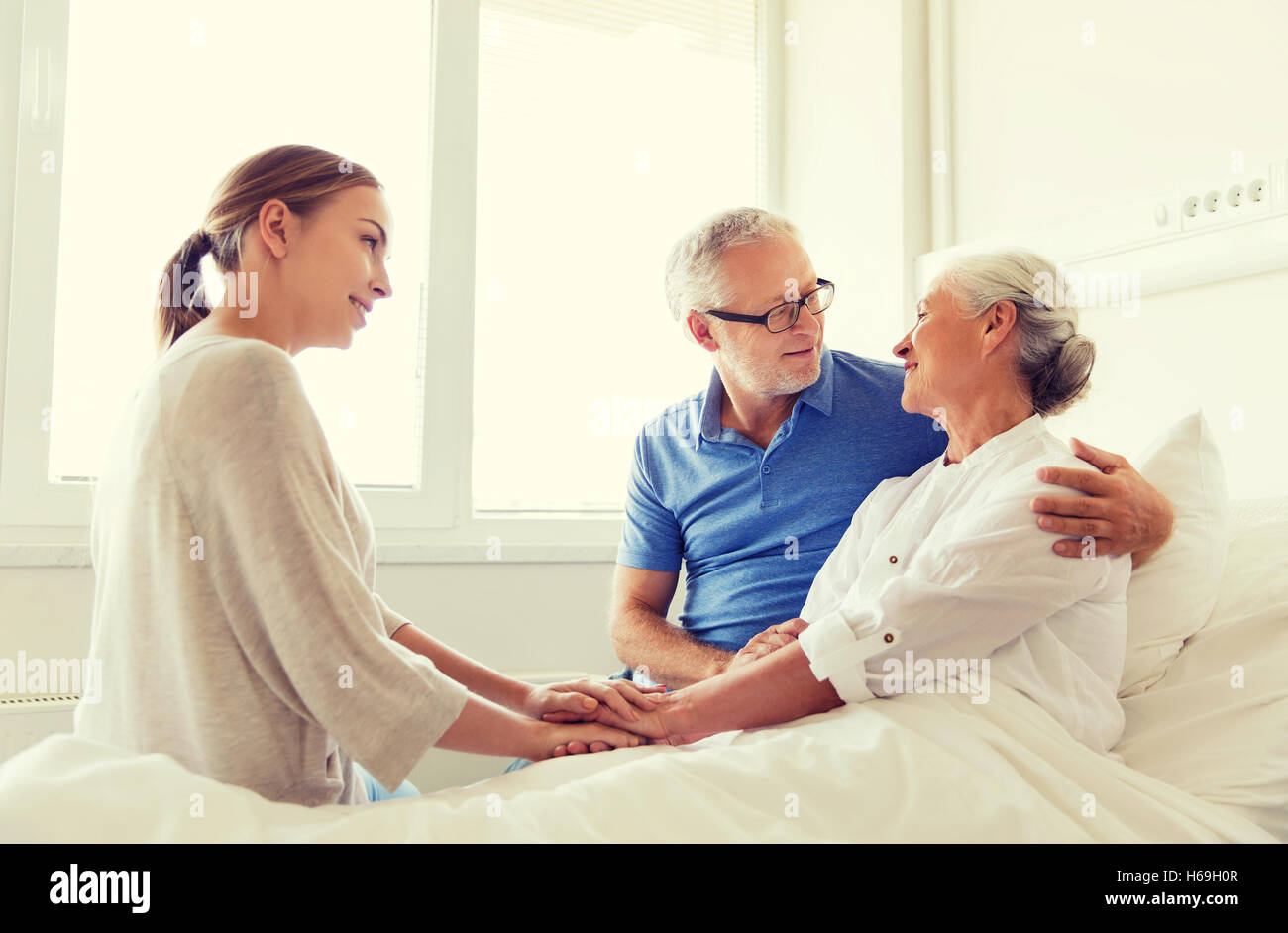 happy family visiting senior woman at hospital Stock Photo - Alamy