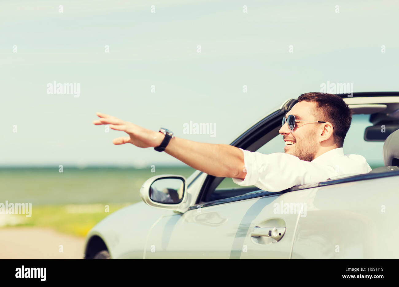 happy man driving cabriolet car and waving hand Stock Photo - Alamy