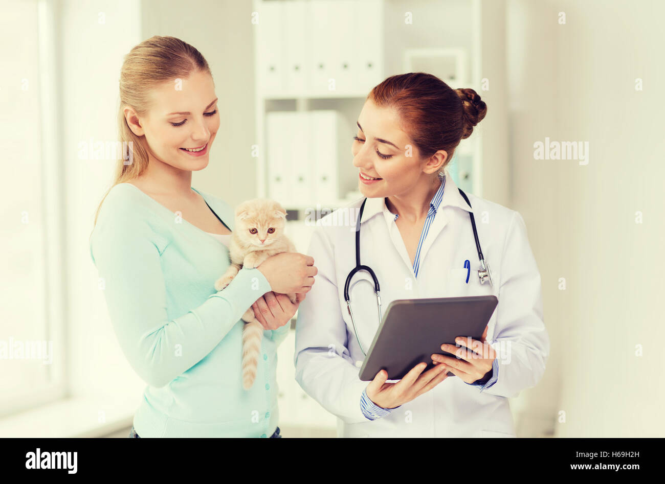 happy woman with cat and doctor at vet clinic Stock Photo - Alamy