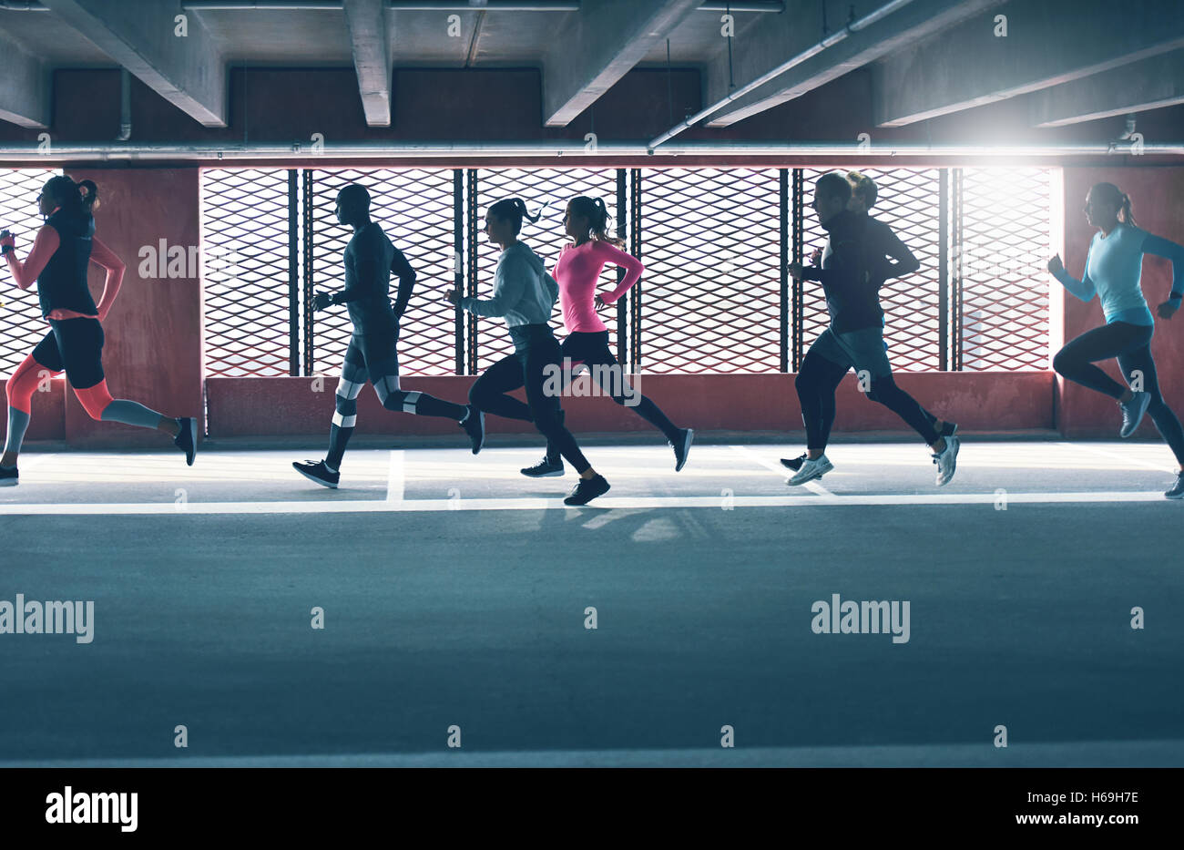 Group of diverse young people urban running in front of the brightly ...