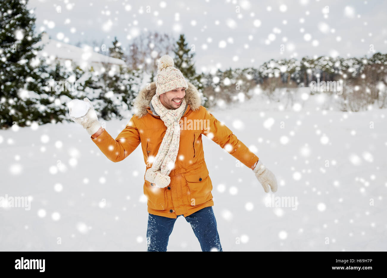 happy young man playing snowballs in winter Stock Photo - Alamy