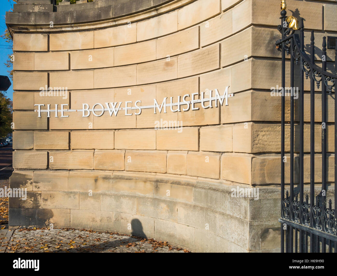 The Bowes Museum sign on a curved stone wall at the front entrance ...