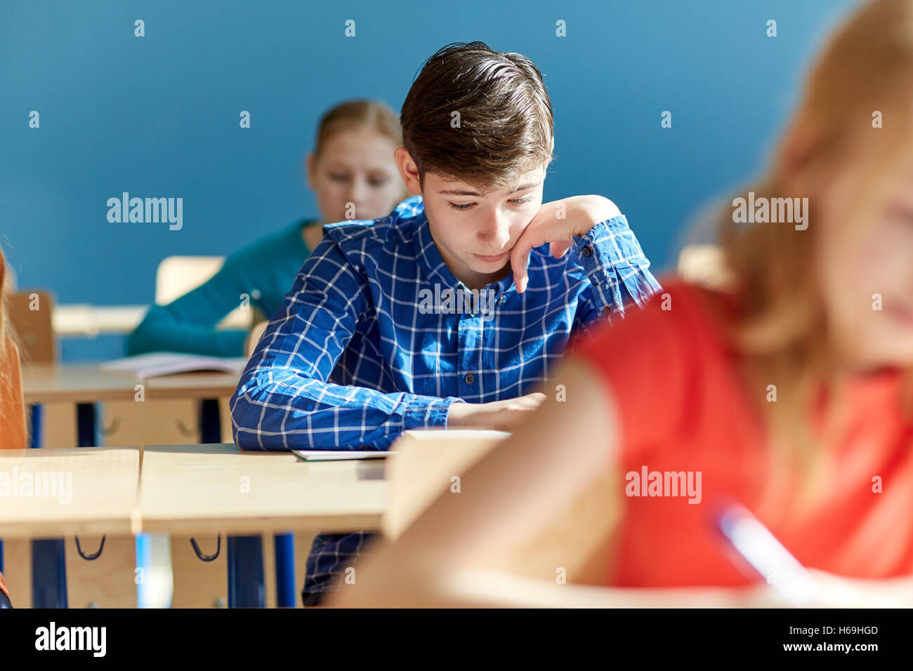 group of students with books writing school test Stock Photo - Alamy