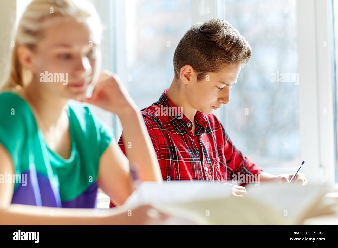 group of students with books writing school test Stock Photo - Alamy