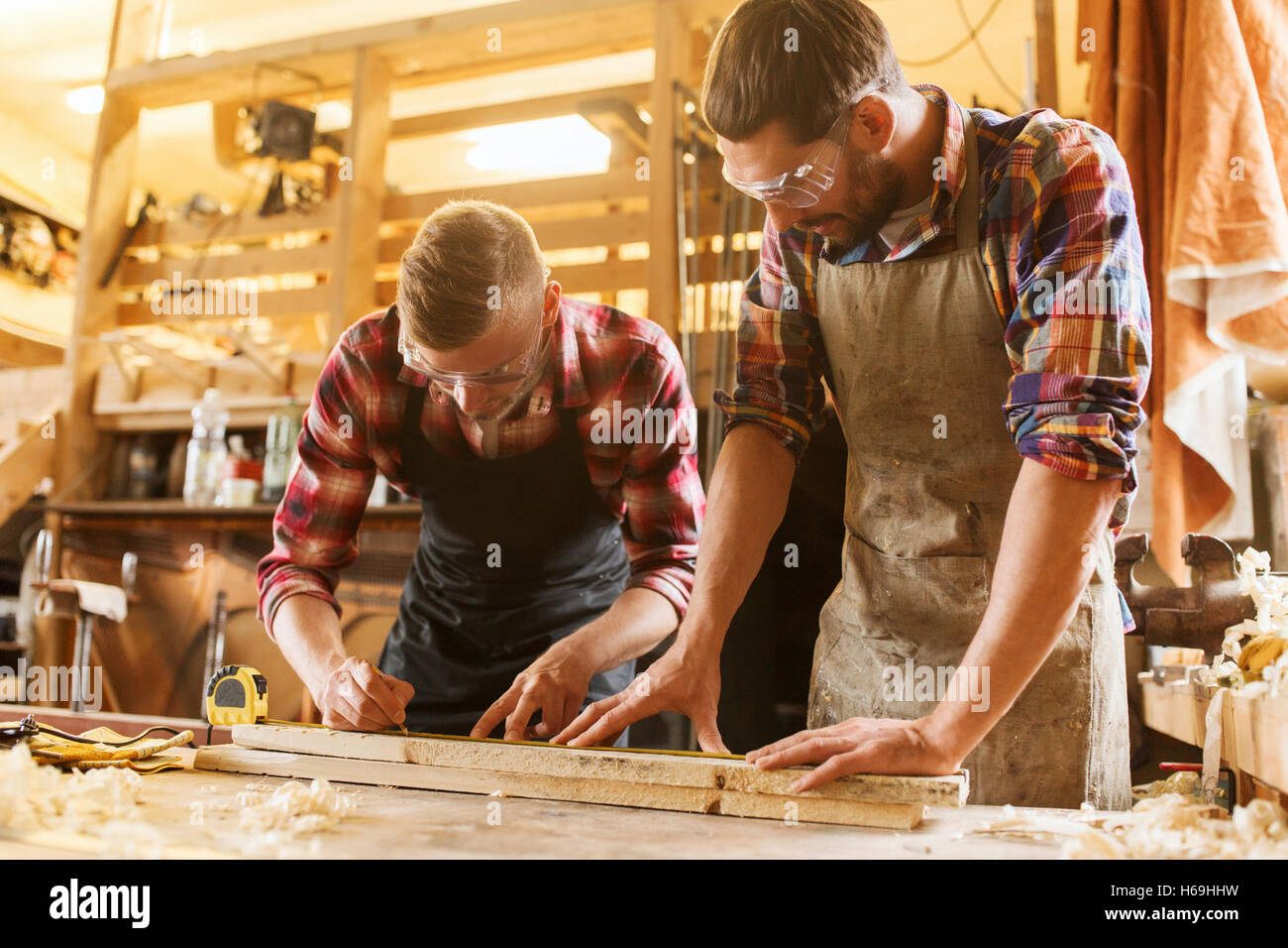 carpenters with ruler and wood plank at workshop Stock Photo - Alamy