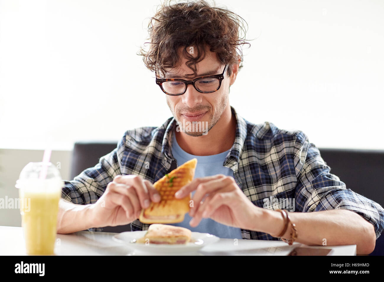 happy man eating sandwich at cafe for lunch Stock Photo - Alamy