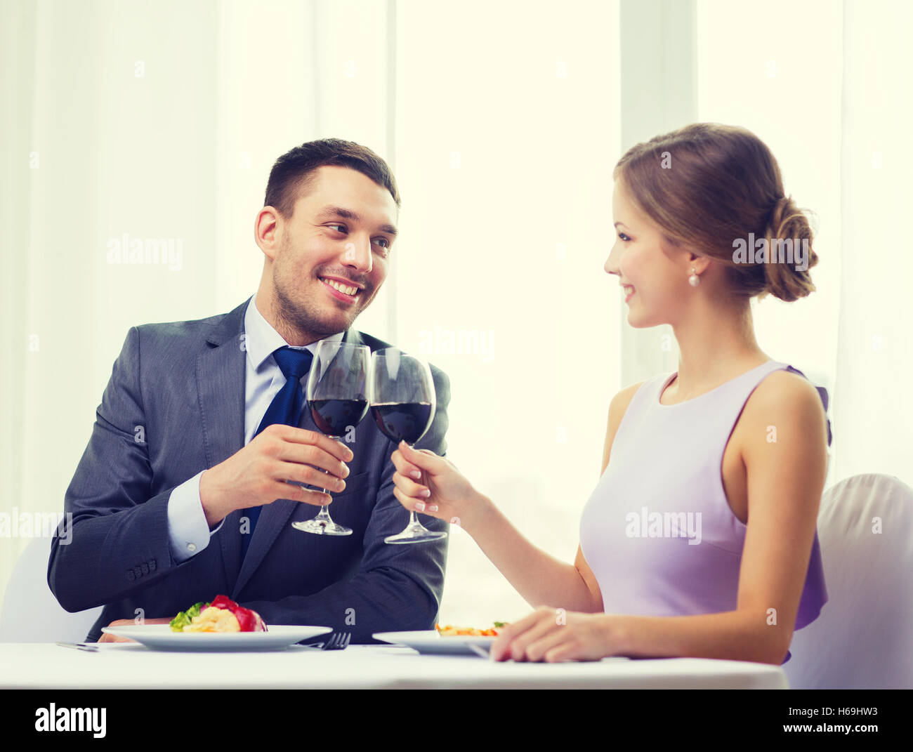 couple with main course and red wine at restaurant Stock Photo - Alamy