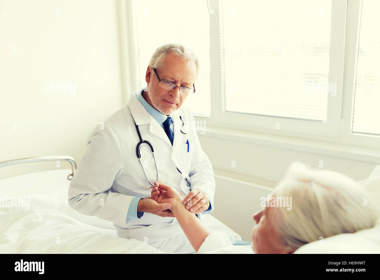 doctor checking senior woman pulse at hospital Stock Photo - Alamy