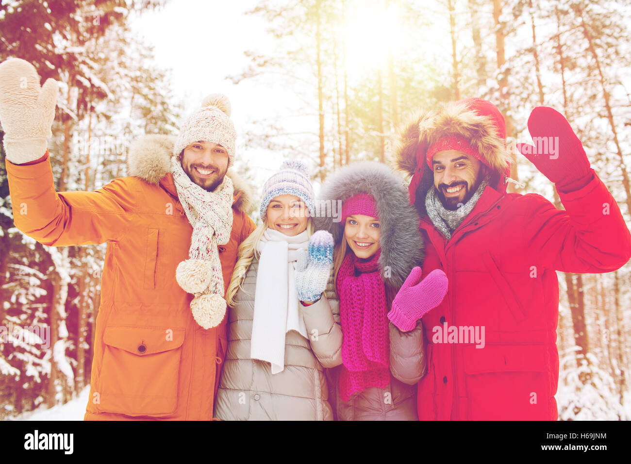 group of friends waving hands in winter forest Stock Photo - Alamy