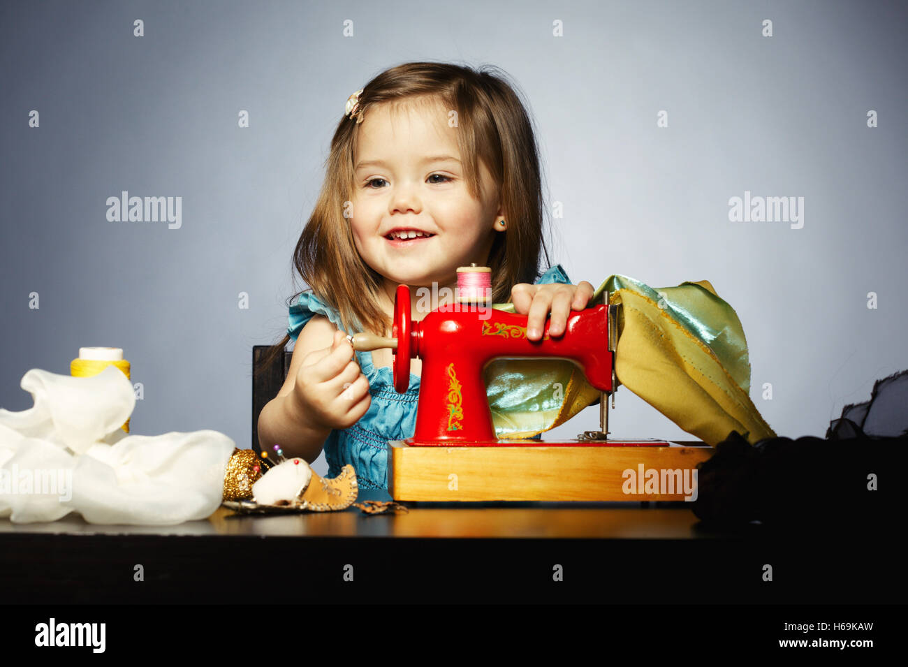 little girl is playing with sewing machine Stock Photo - Alamy
