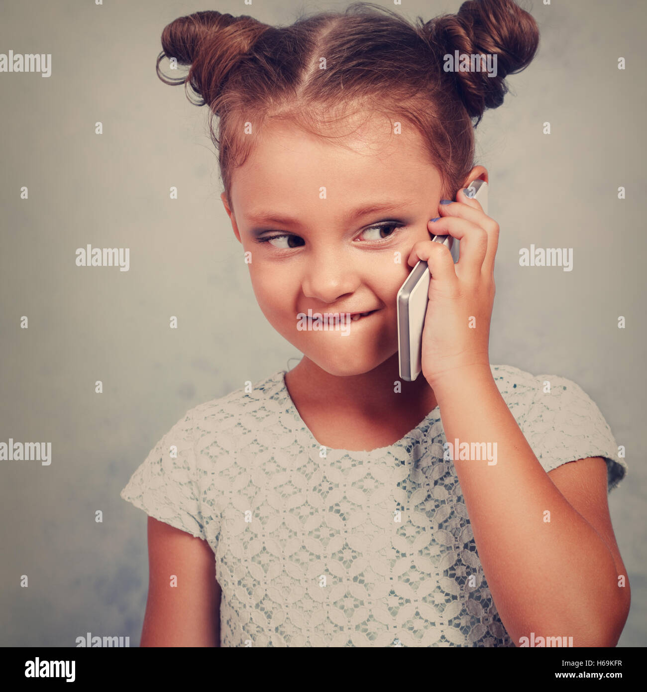 Funny kid girl talking on mobile phone with happy smile on blue ...