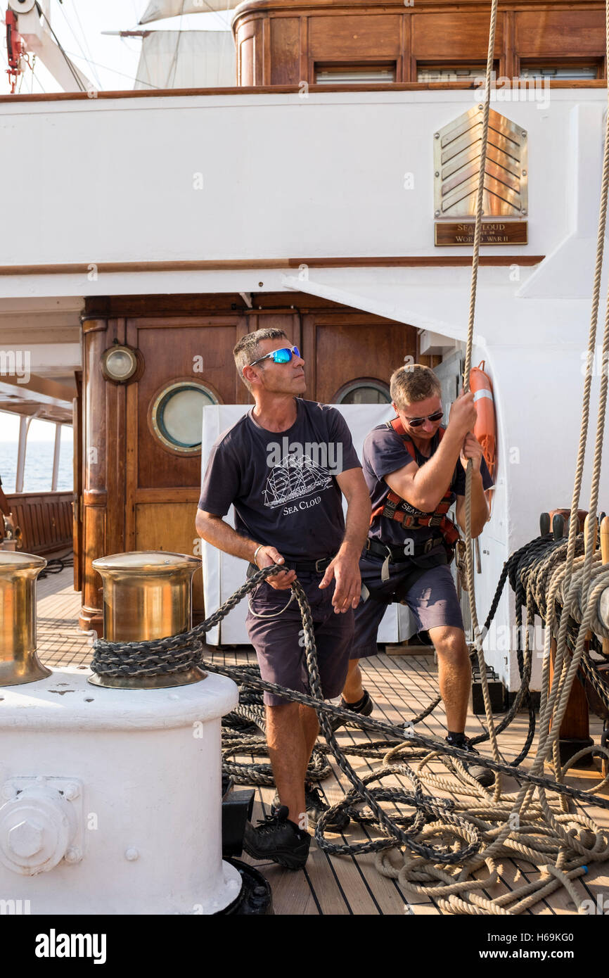 Sailors work to secure the sails on the historic S.Y. Sea Cloud tall ...