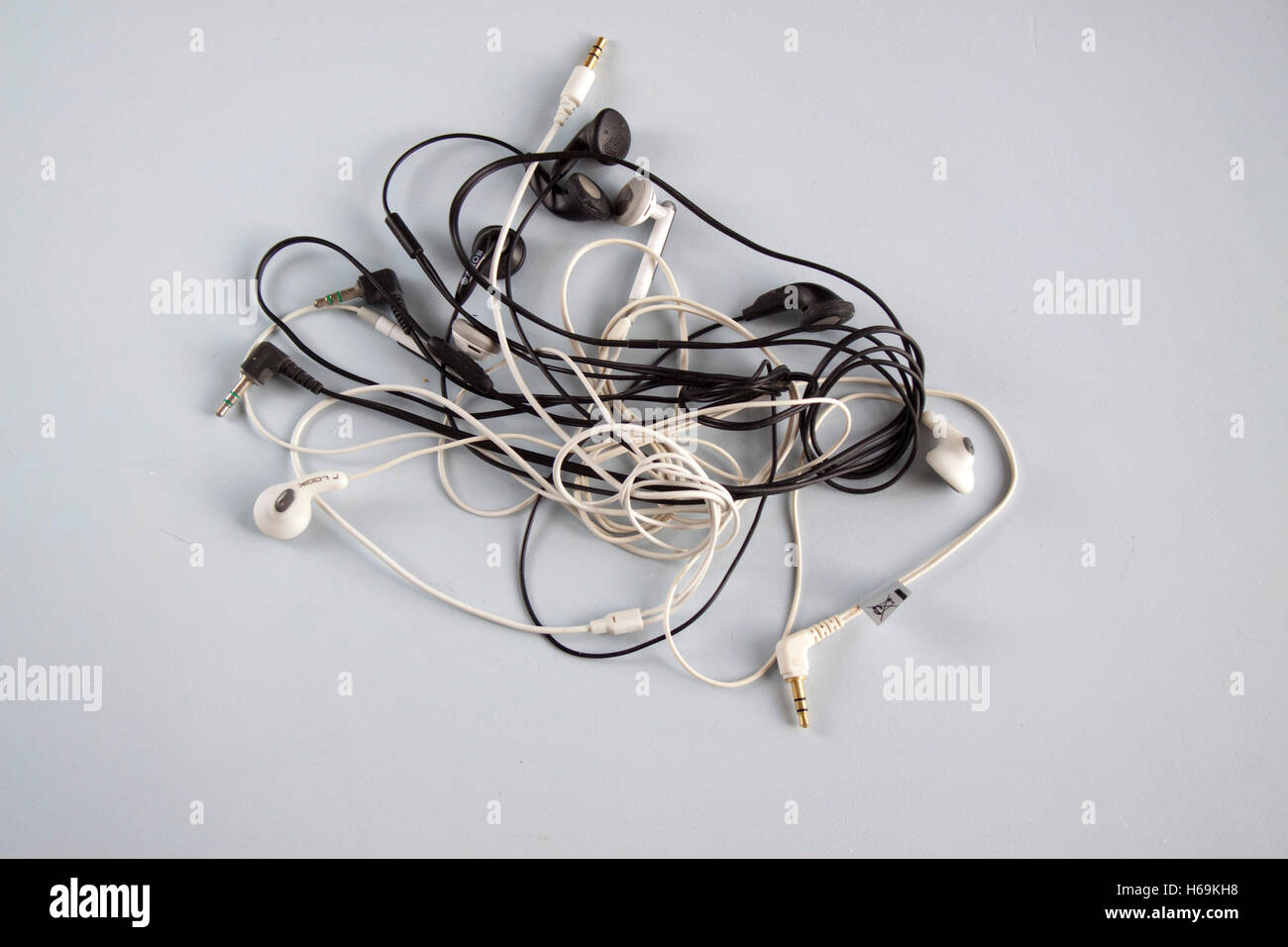 A tangle of in ear headphones Stock Photo - Alamy