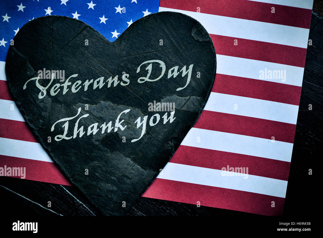 a heart-shaped piece of slate stone with the text veterans day, thank ...