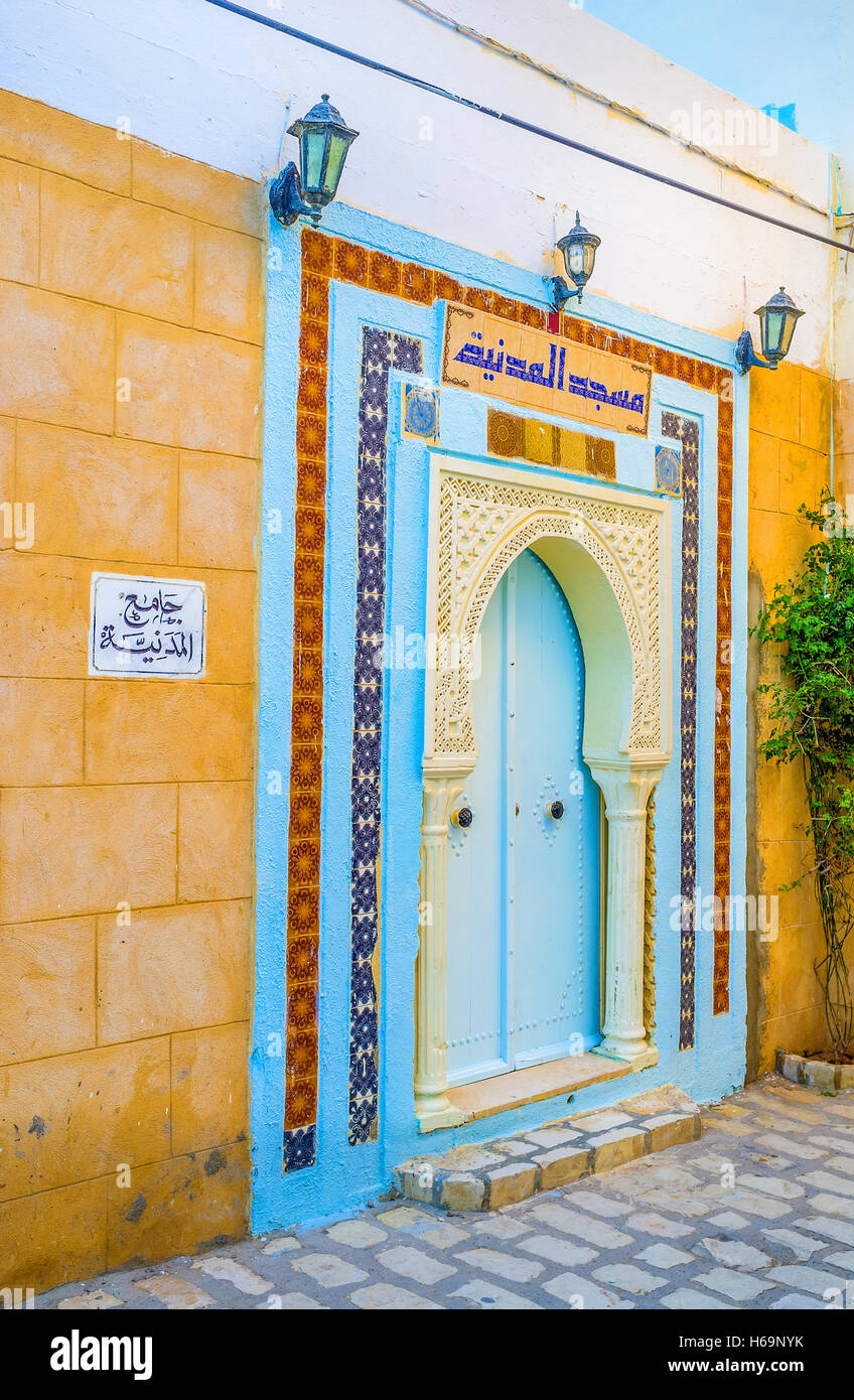 The mosque entrance with the door frame decorated with glazed tiles and ...