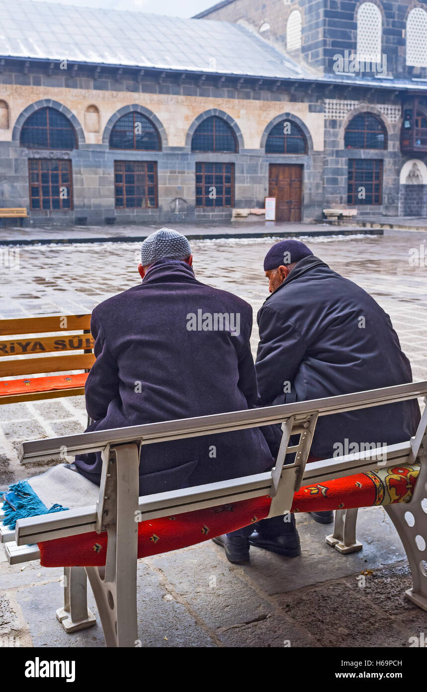 Two muslims sit on the bench and talk in the courtyard of the Great ...