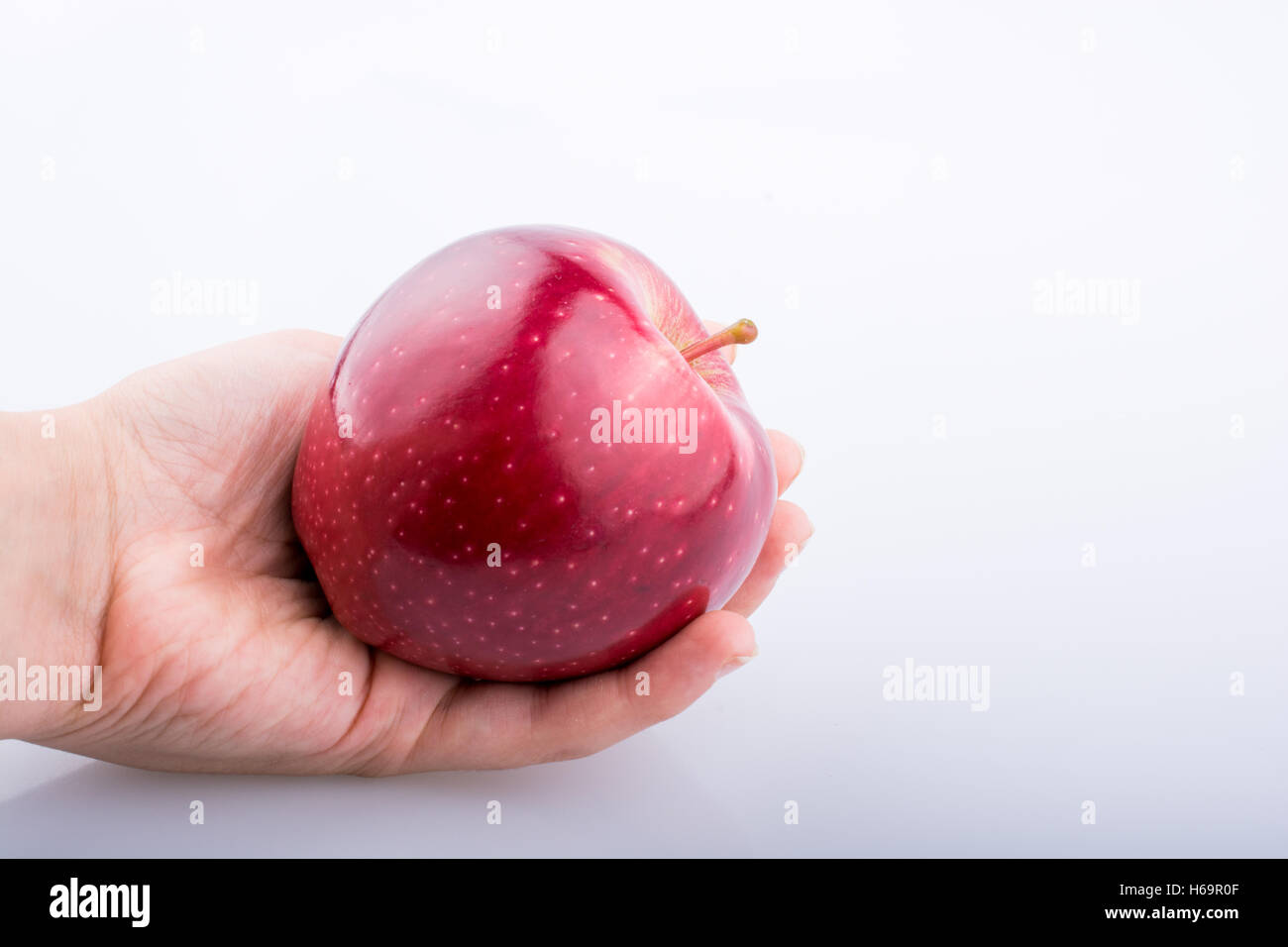 Hand holding a beautiful red apple on a white background Stock Photo ...