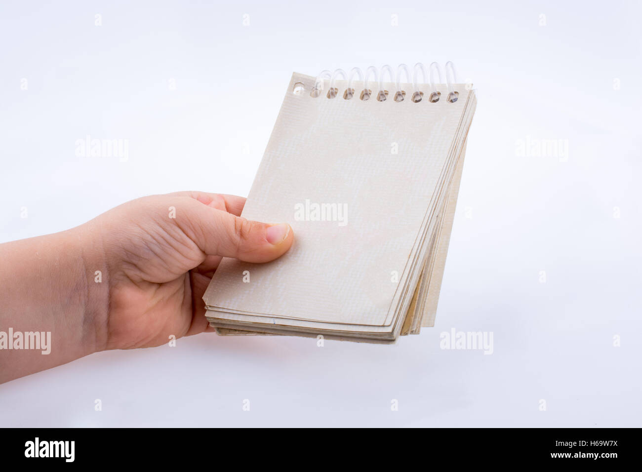 Hand holding brown color notebook on a white background Stock Photo - Alamy