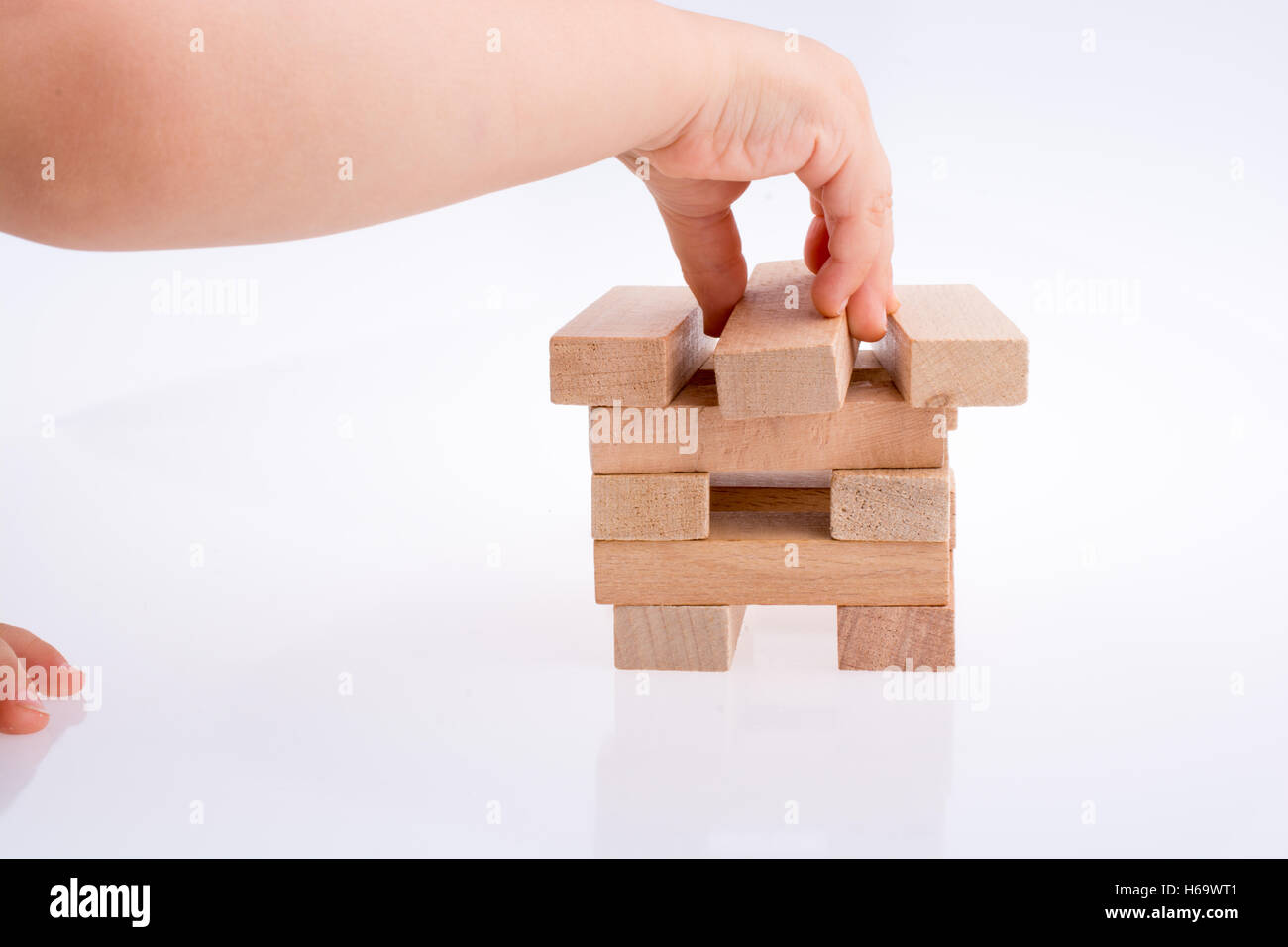 Hand playing with wooden building blocks on white background Stock ...