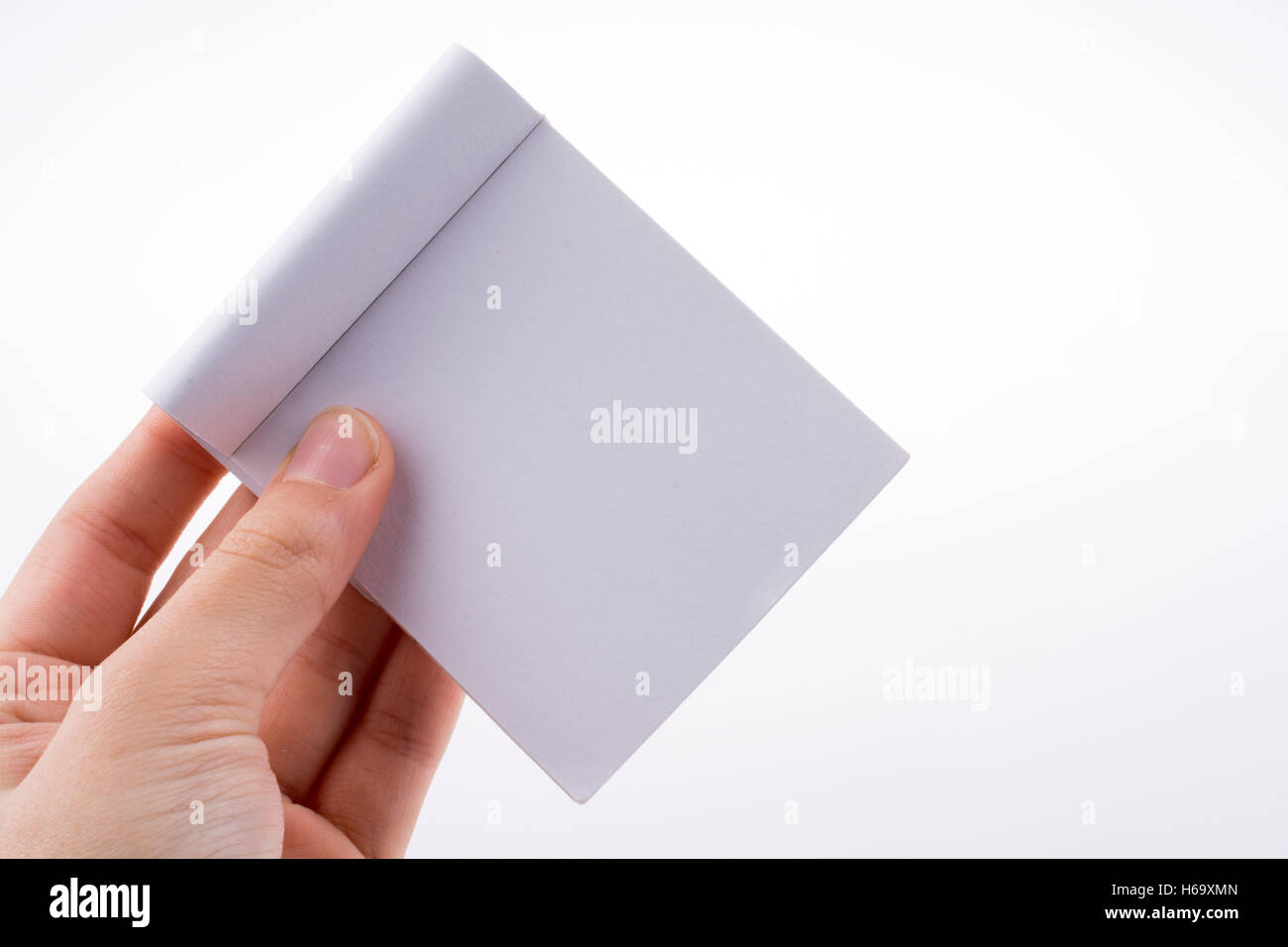 Hand holding white color notebook on a white background Stock Photo - Alamy