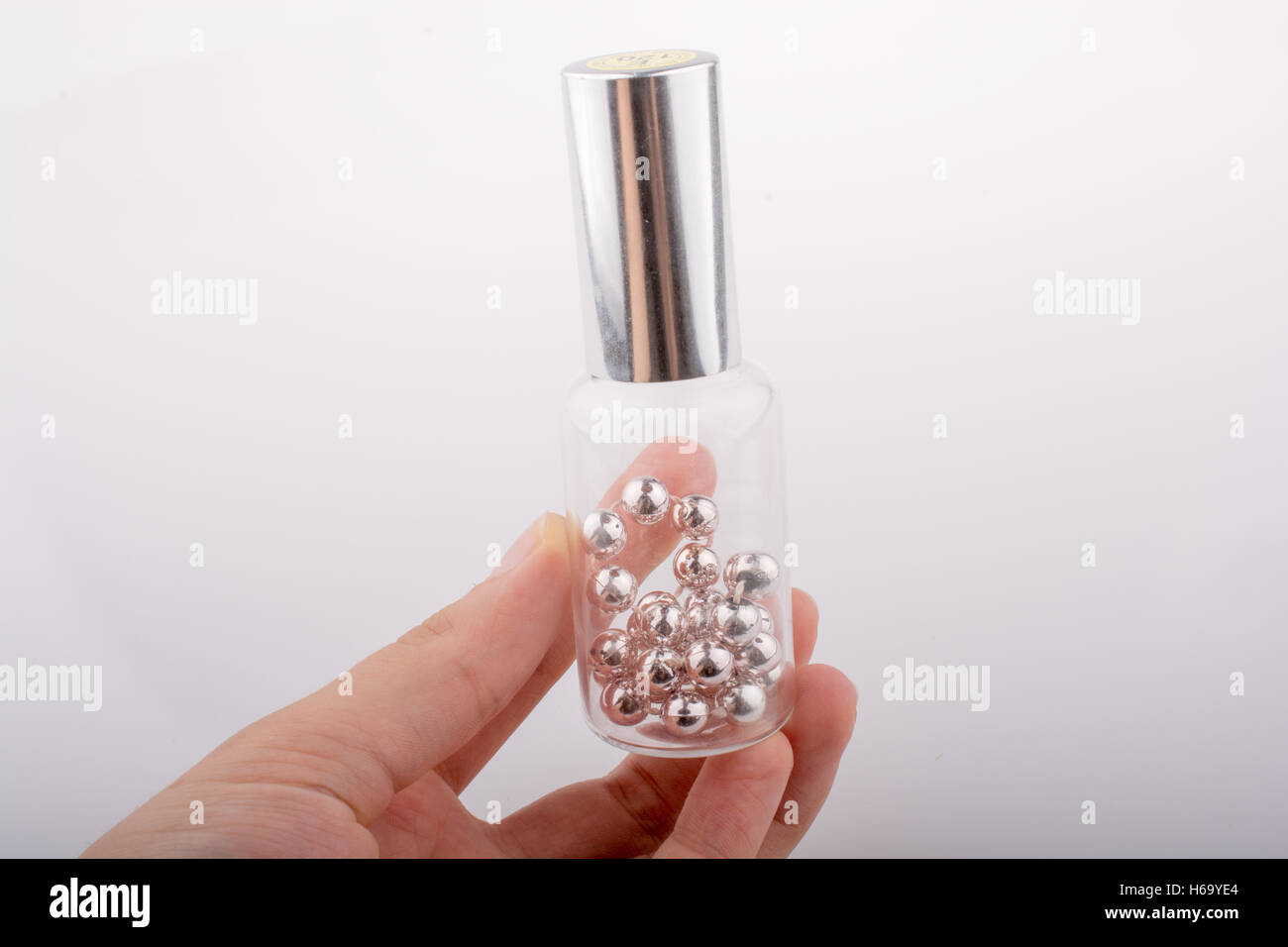 Little glass bottle in hand on a white background Stock Photo - Alamy