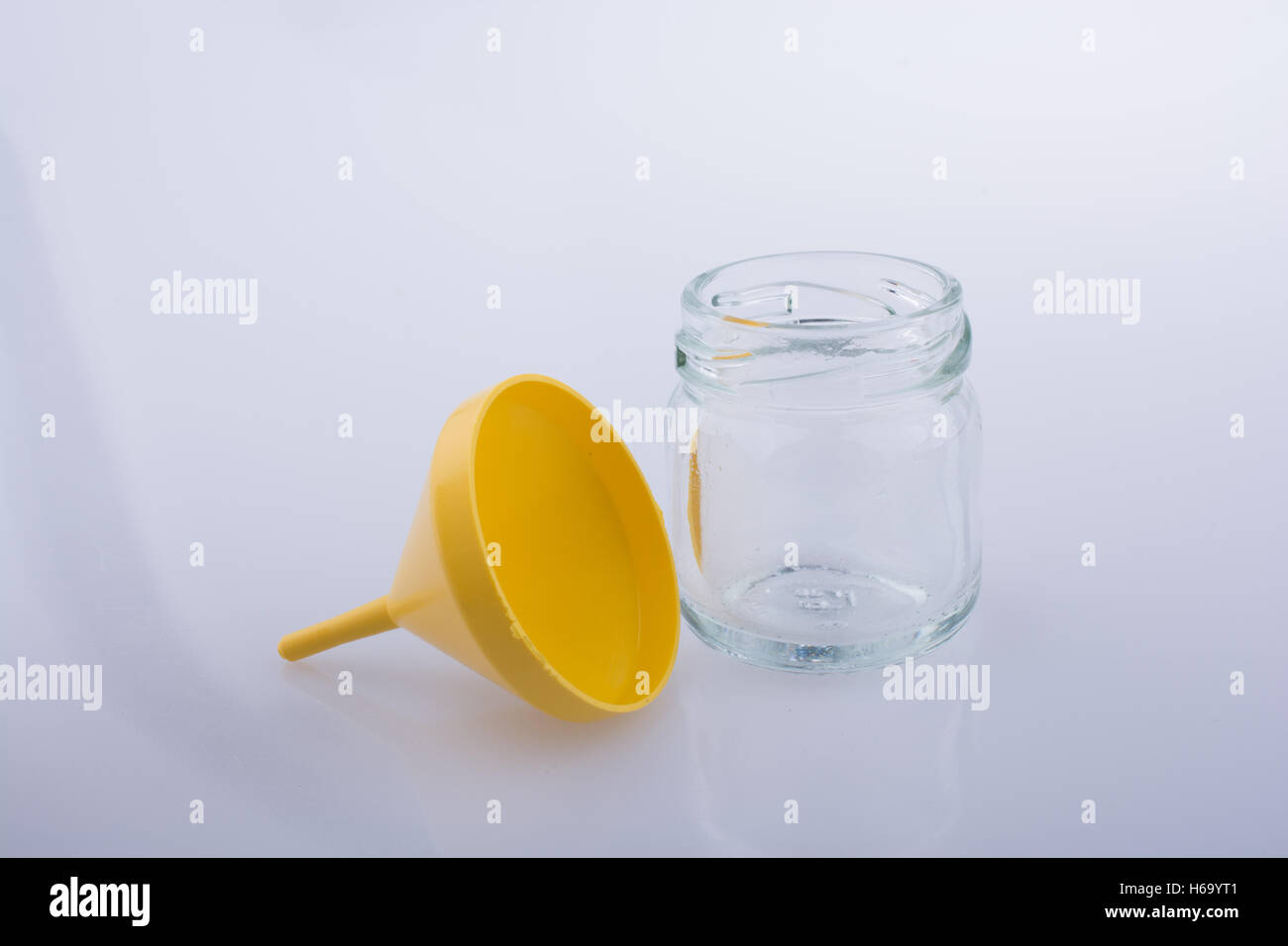 Little glass bottle and a funnel on a white background Stock Photo - Alamy