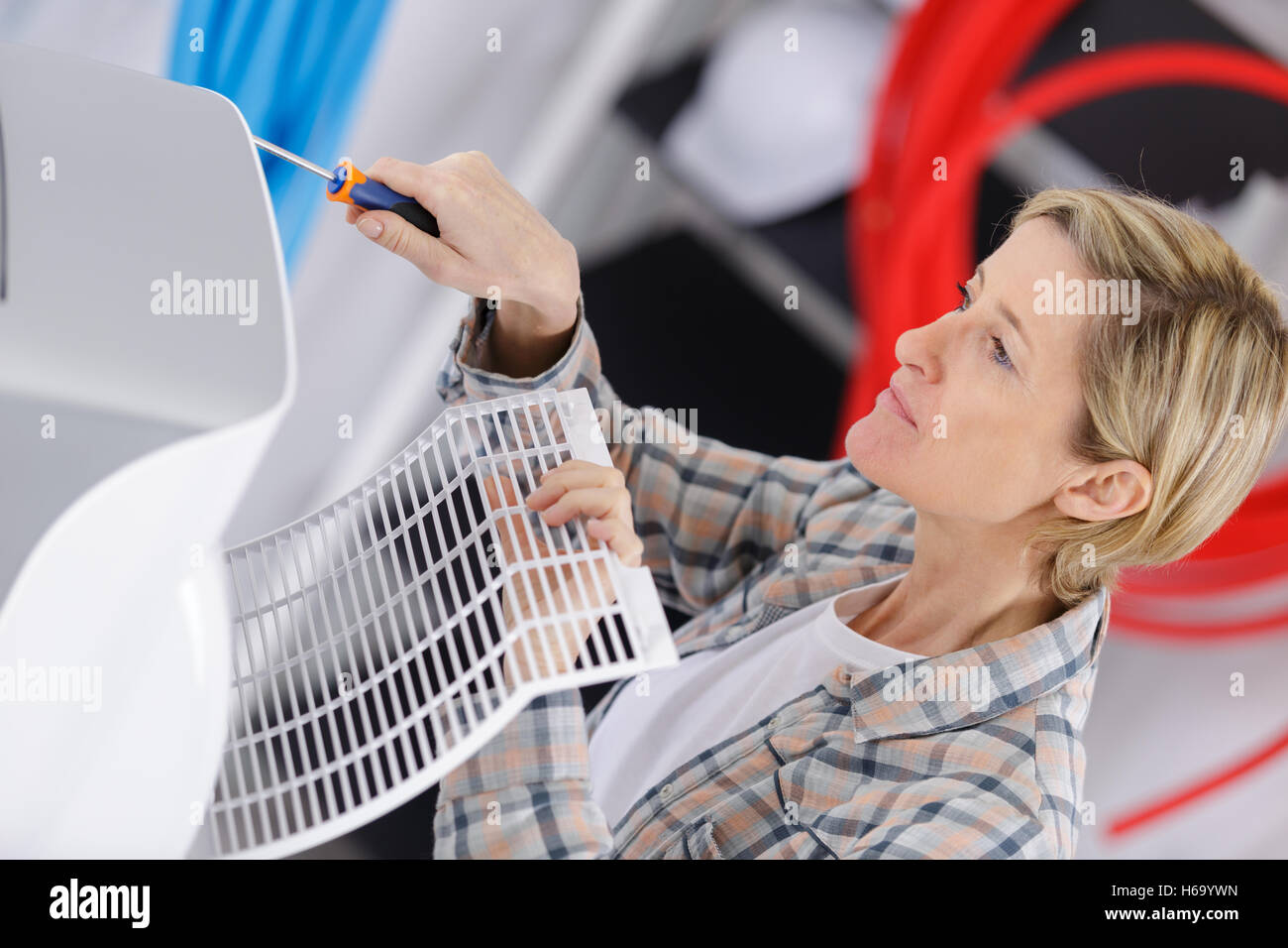 young woman fixing air conditioner in house Stock Photo - Alamy