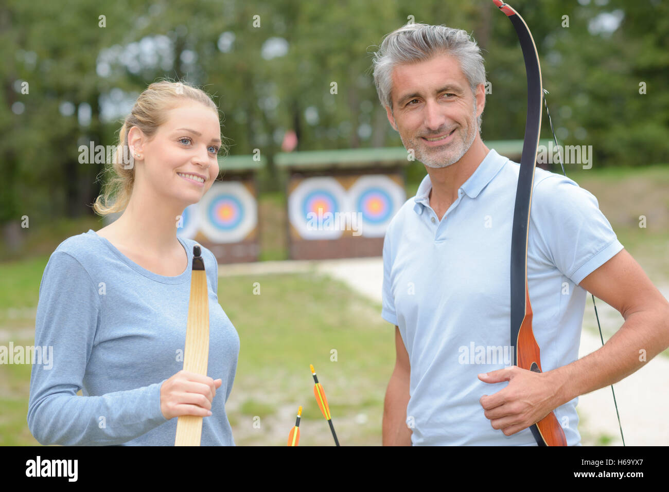 Couple holding bows and arrows Stock Photo - Alamy