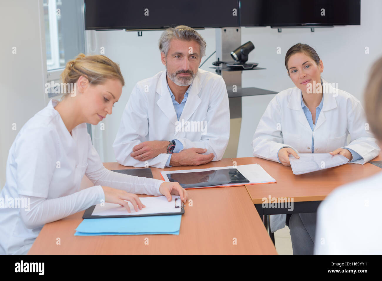 Medics sat around table in discussion Stock Photo - Alamy