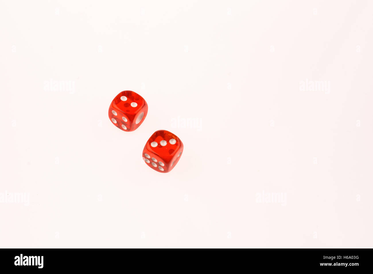 Two red color dice on a table on a sunny day Stock Photo - Alamy